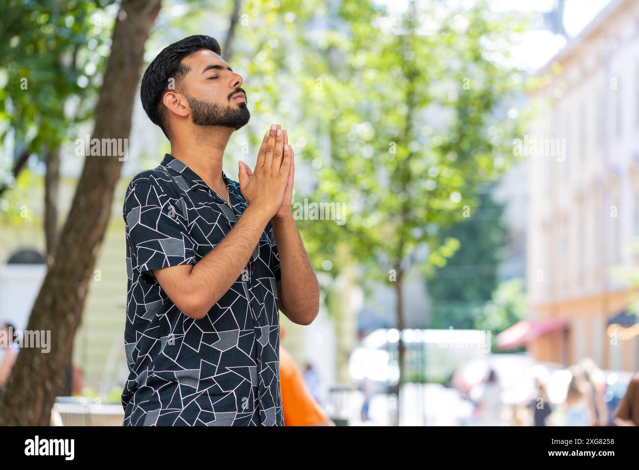 Bearded religion Indian man tourist praying with closed eyes to God ...
