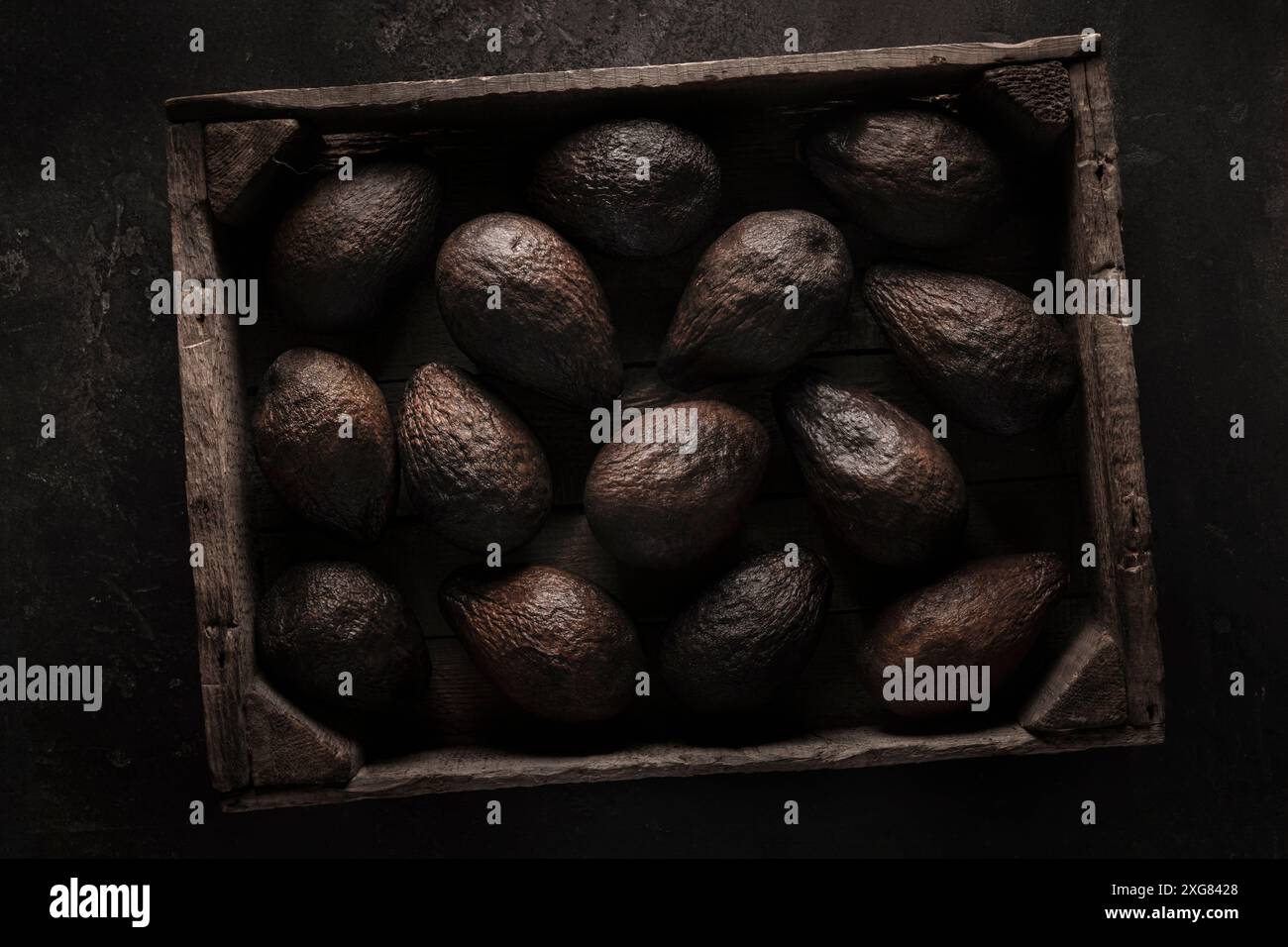 Old blackened brown avocados in an old wooden box - Beautiful dark ...