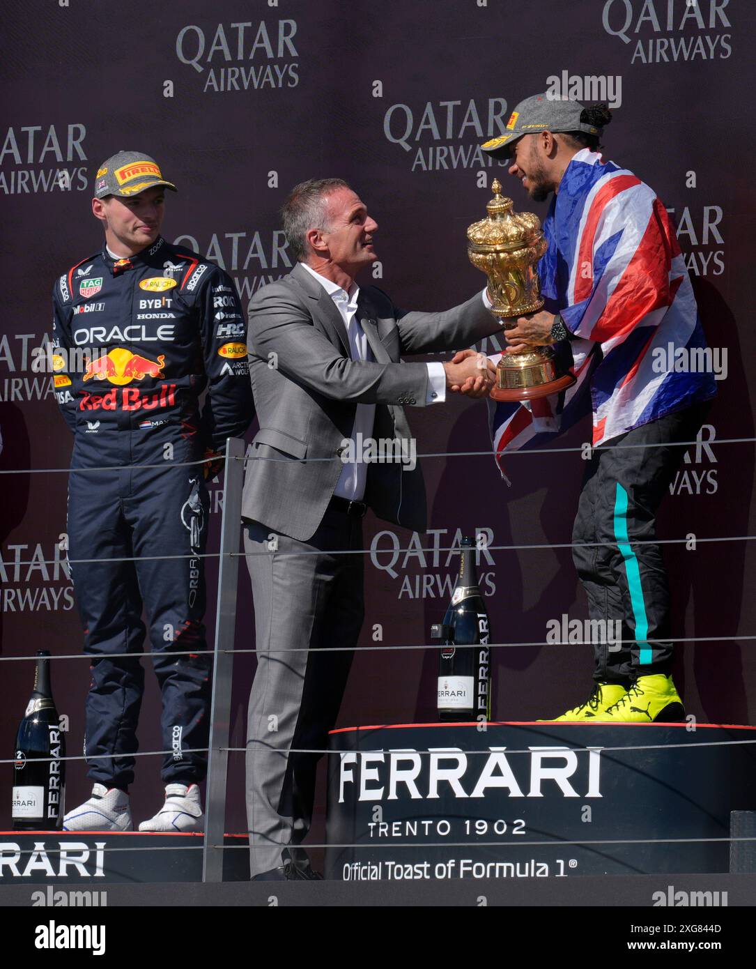 Mercedes driver Lewis Hamilton (left) is handed the British Grand Prix ...