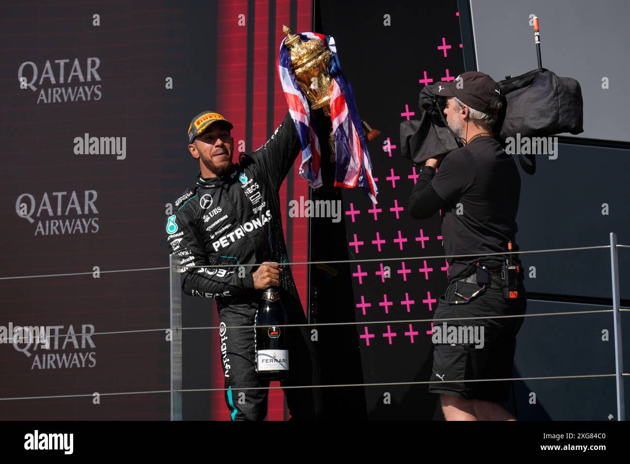 Mercedes driver Lewis Hamilton lifts the British Grand Prix Trophy as ...