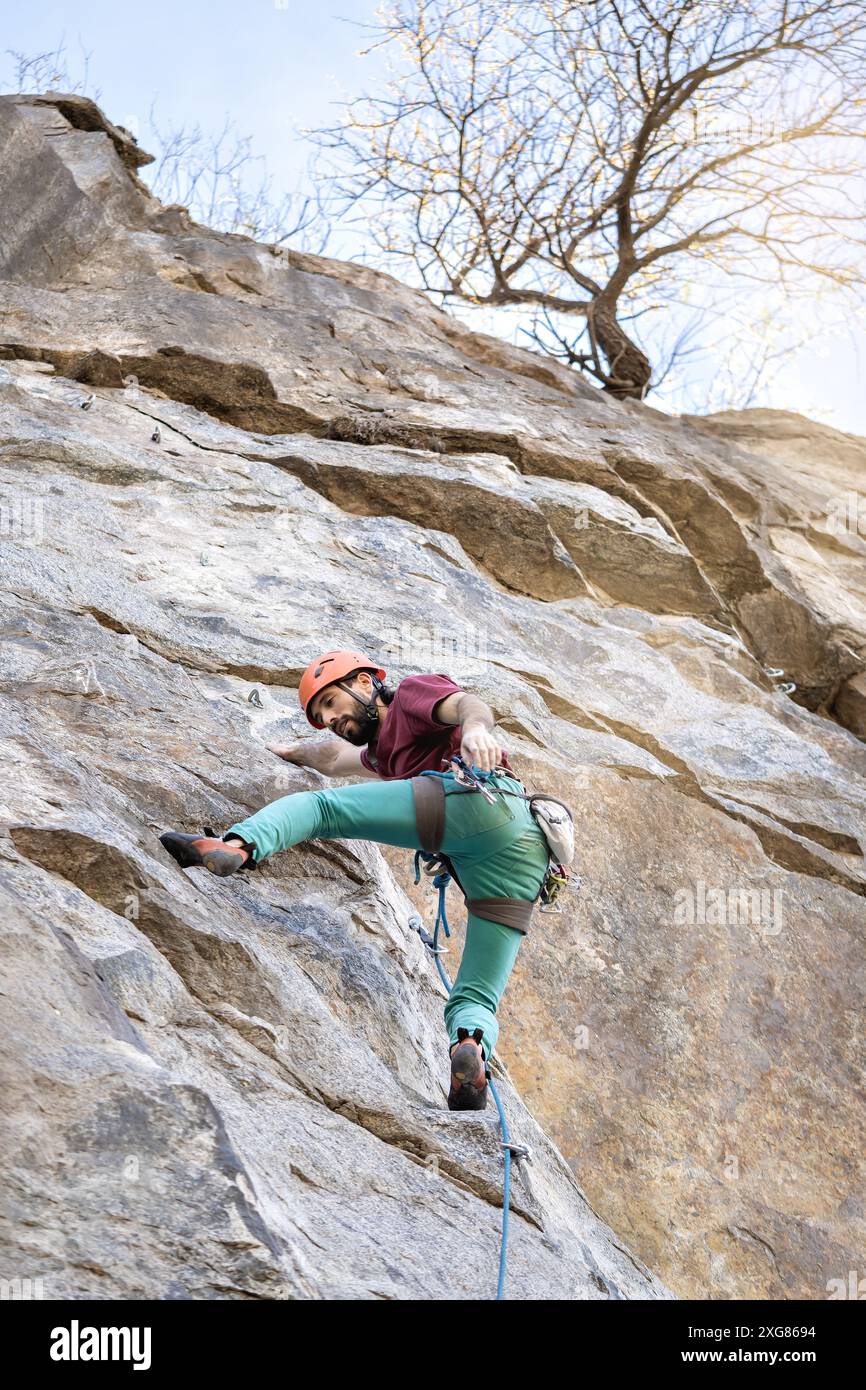 A young man tackles a steep cliff route, exemplifying the thrill and ...