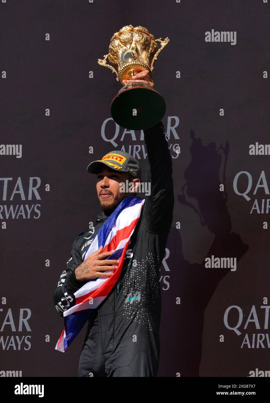 Mercedes driver Lewis Hamilton lifts the British Grand Prix Trophy as ...