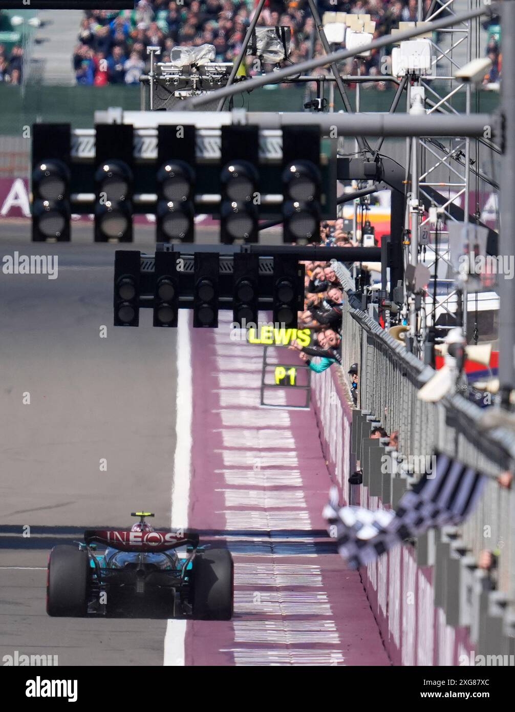Mercedes driver Lewis Hamilton drives past the checkered flag as he ...