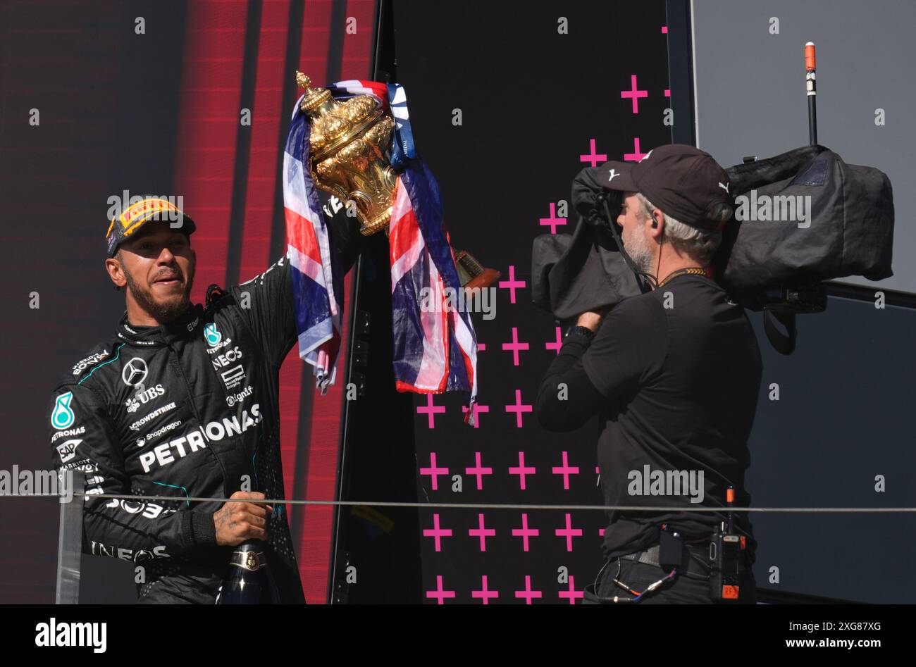 Mercedes driver Lewis Hamilton lifts the British Grand Prix Trophy as ...