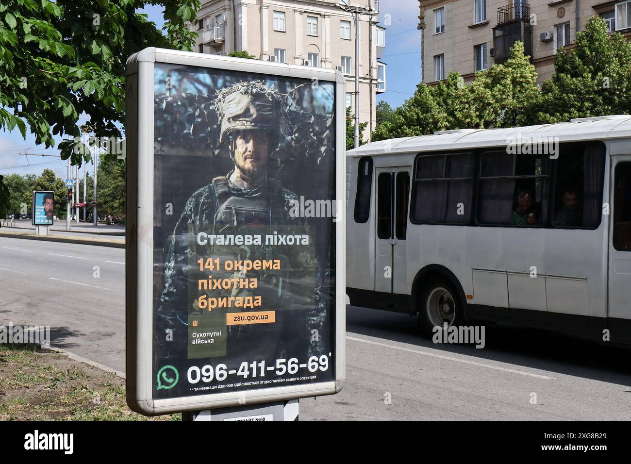 Passengers in a bus drive by the recruitment poster for the Ukrainian ...