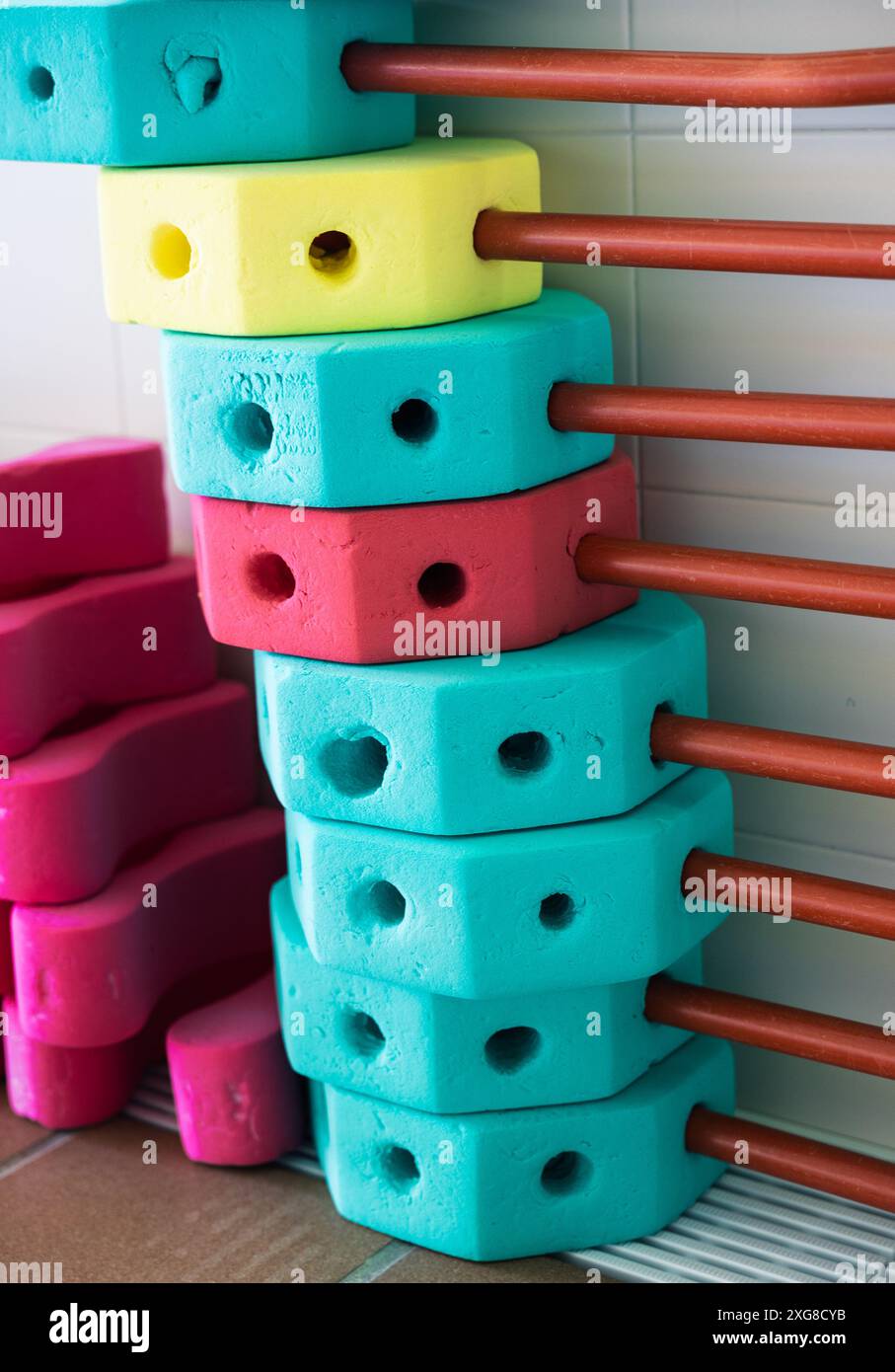 Various colored foam floaters stacked neatly on the floor of an indoor ...