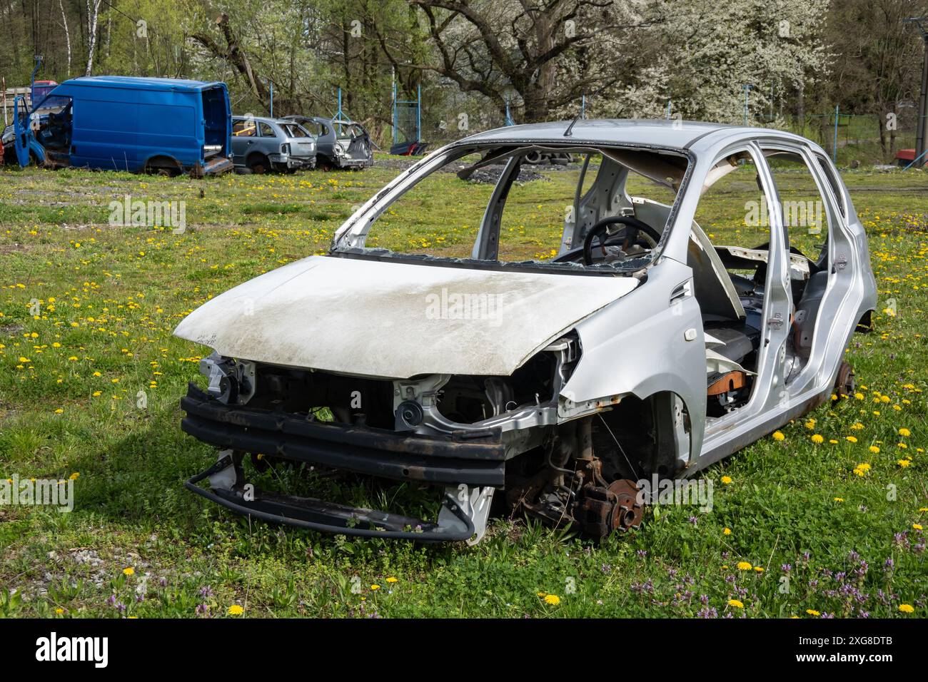 Wreck of old silver car in junkyard without doors and other spare parts ...
