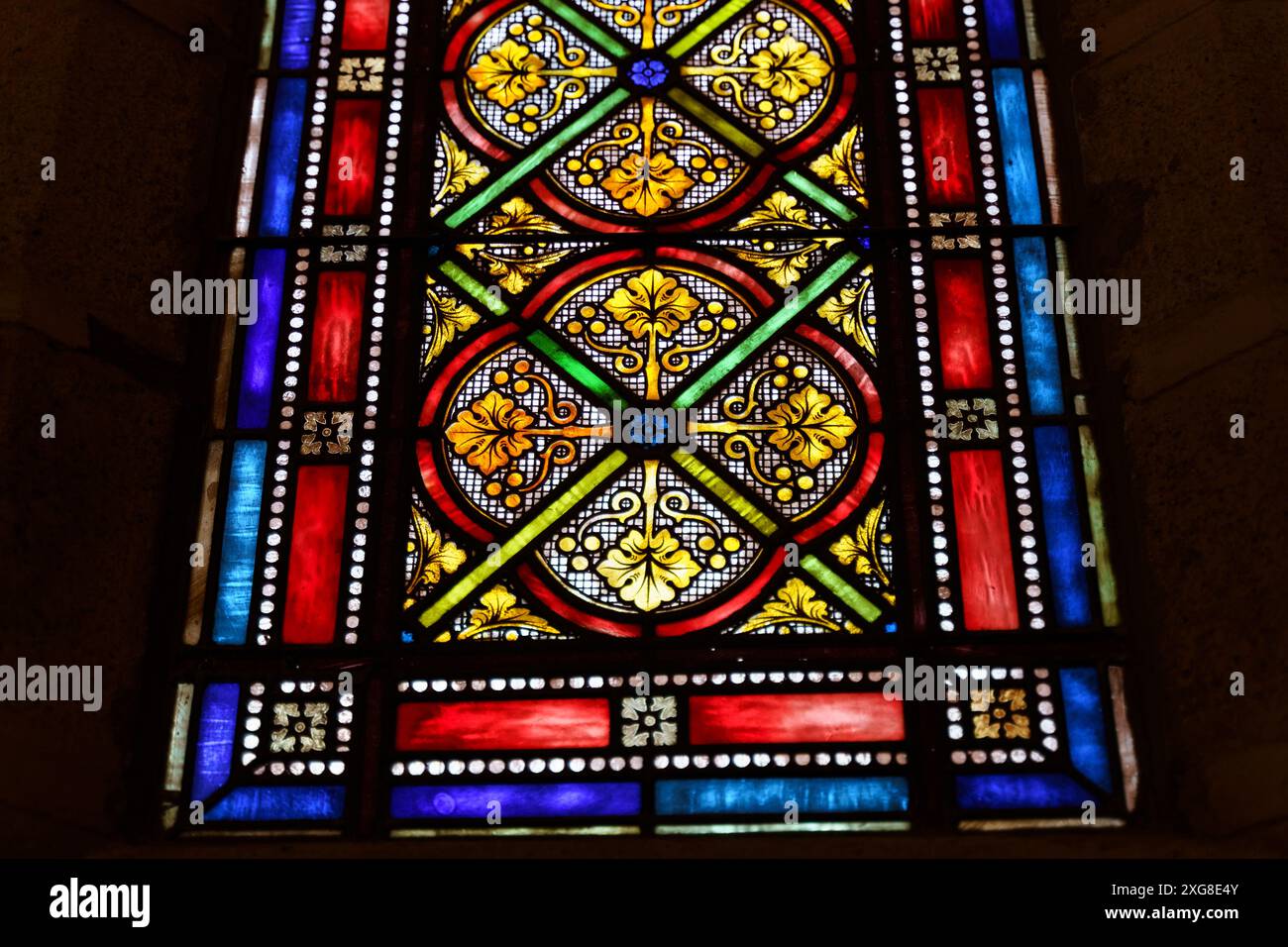 A close-up view of a vibrant stained glass window in a church, showcasing intricate religious ...