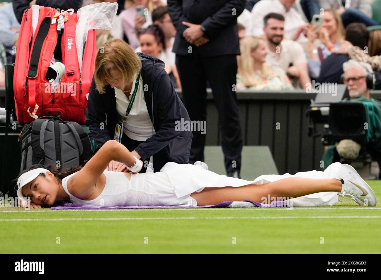 Emma Raducanu of Britain receives medical treatment after a fall during ...