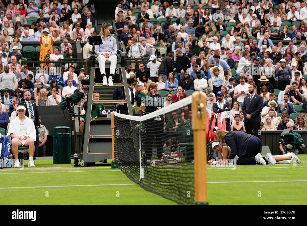 Emma Raducanu, right, of Britain receives medical treatment after a ...