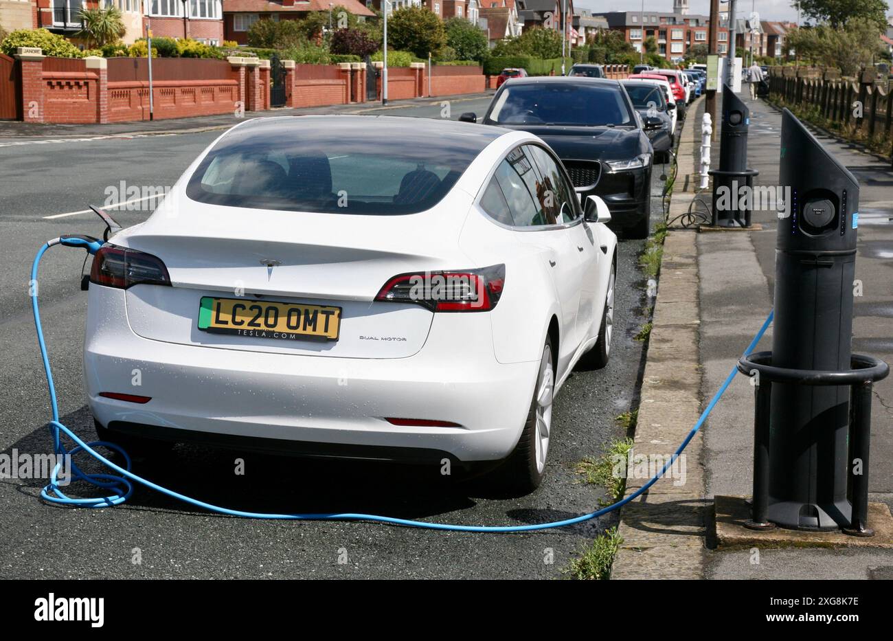 A Tesla motor vehicle, on charge at the roadside, Lytham St Annes ...