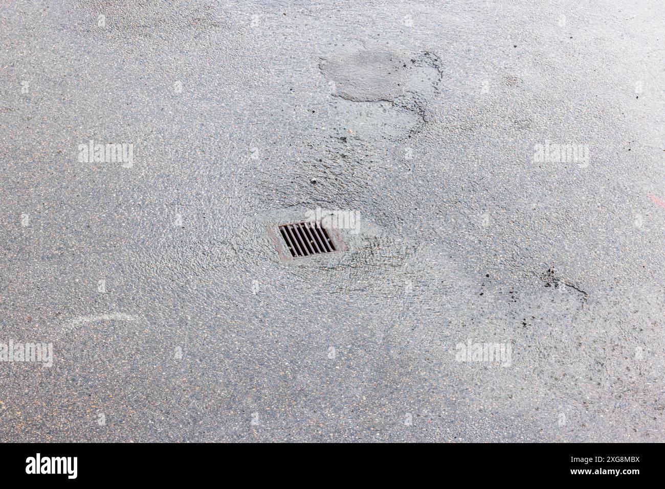 Storm drain grate in asphalt collecting water during heavy rain. Sweden ...