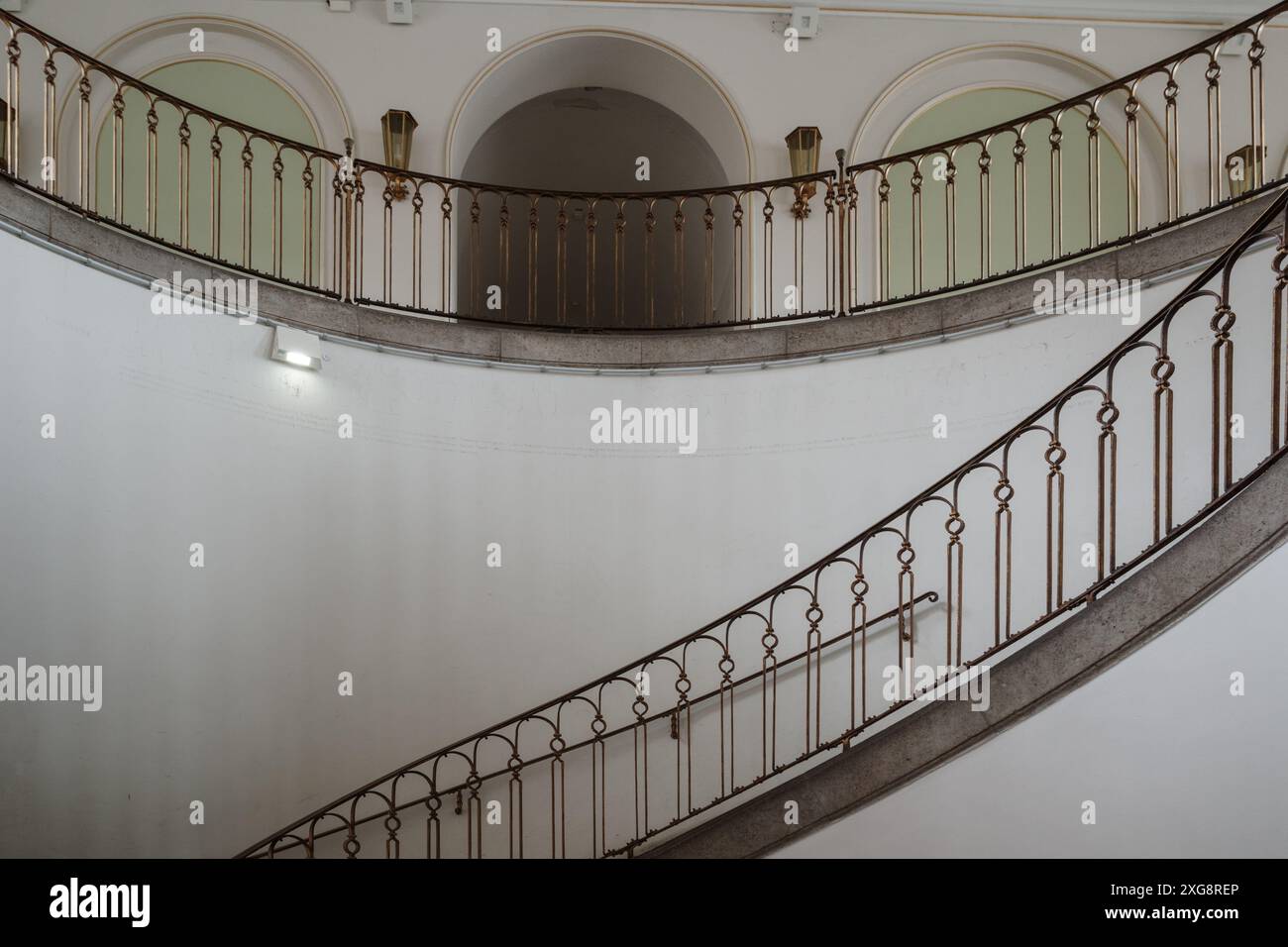 A beautifully designed curved staircase with ornate metal railings ...