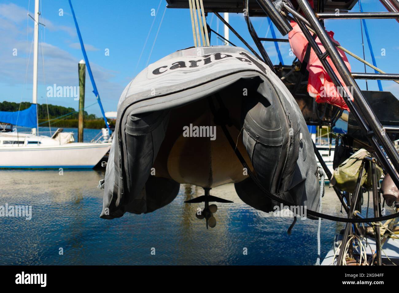 An inflatable dinghy that is deflated and hanging on the back of a ...