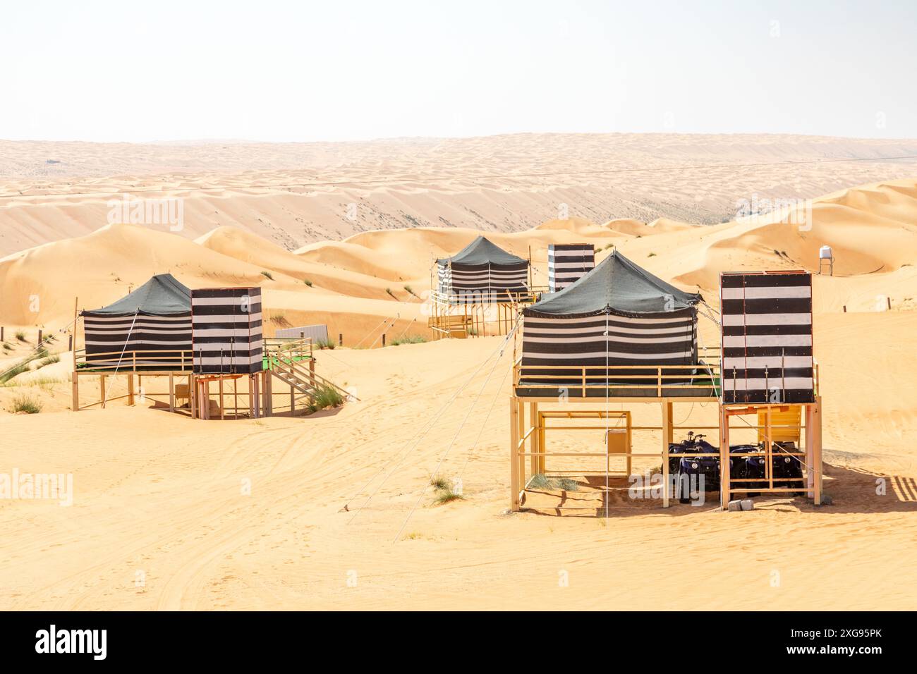 Desert camping tents standing above the sands in the middle of Wahiba ...