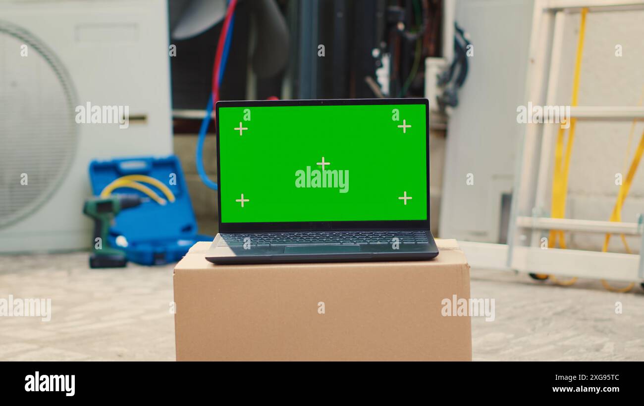 Green screen laptop in front of malfunctioning outdoor condenser. Mock ...