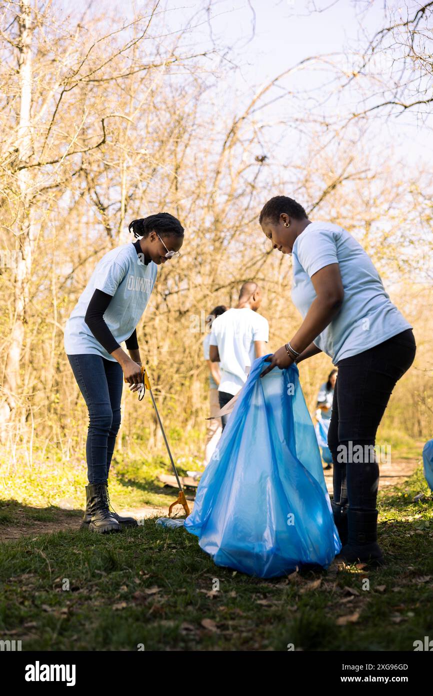 African american volunteers team working to tidy up the forest of ...