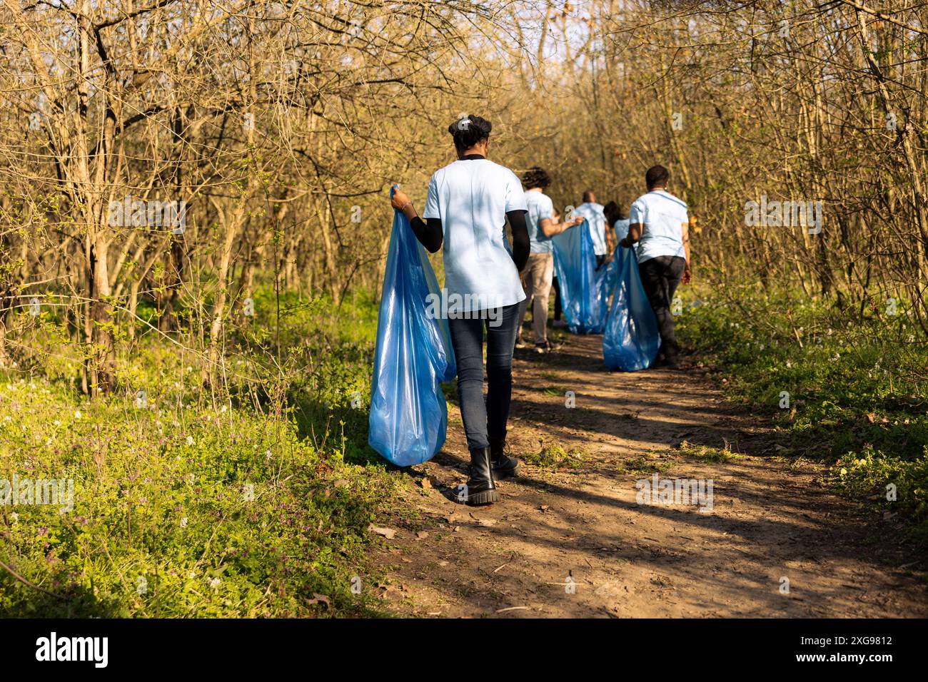 African american activist collecting trash and recycling in a blue bag ...