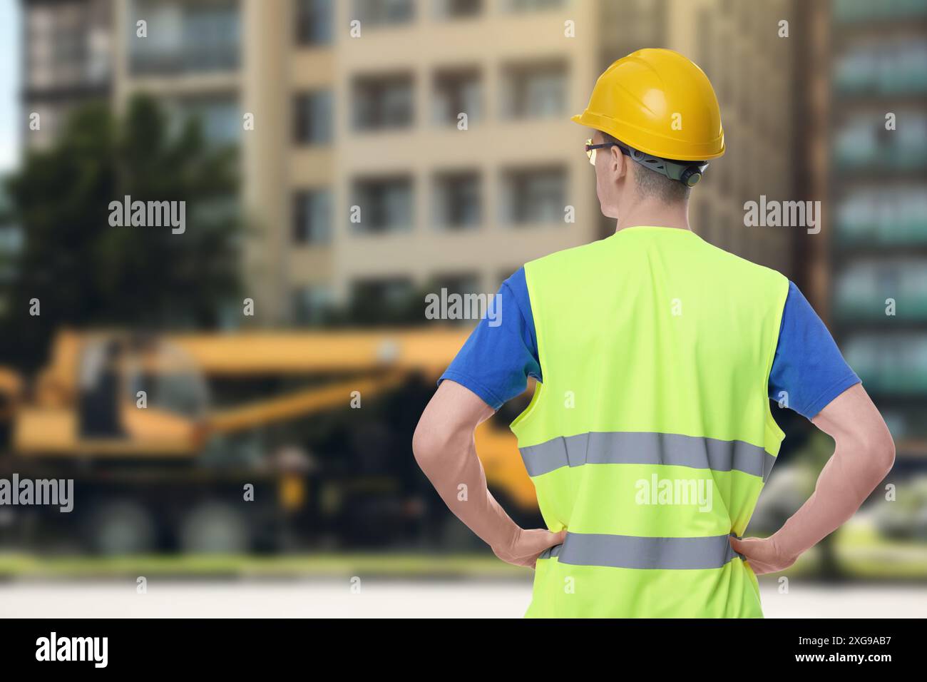 Man wearing safety equipment at construction site, back view. Space for ...