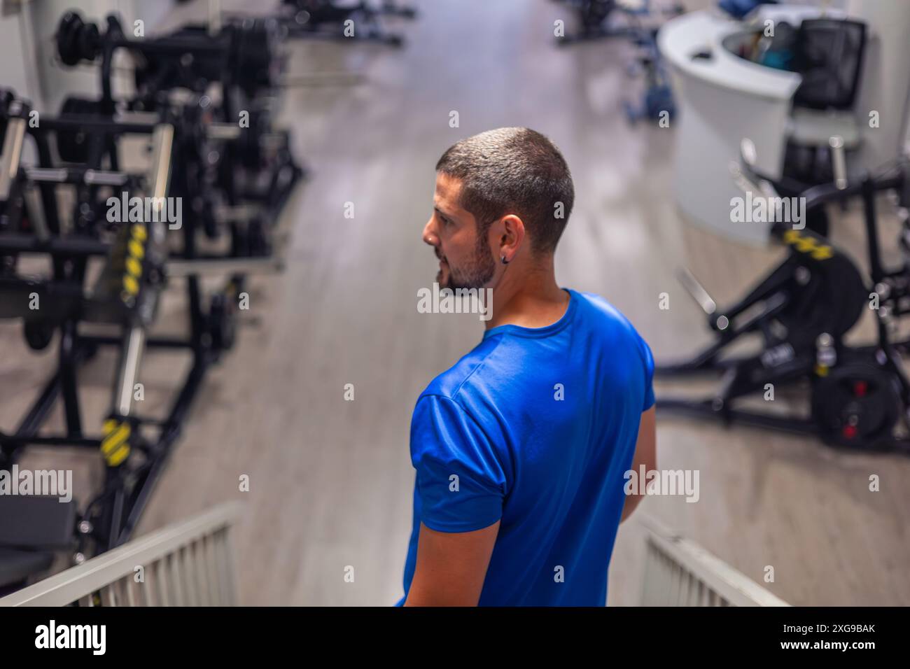 young fitness athlete descends the gym stairs, prepared to begin his ...
