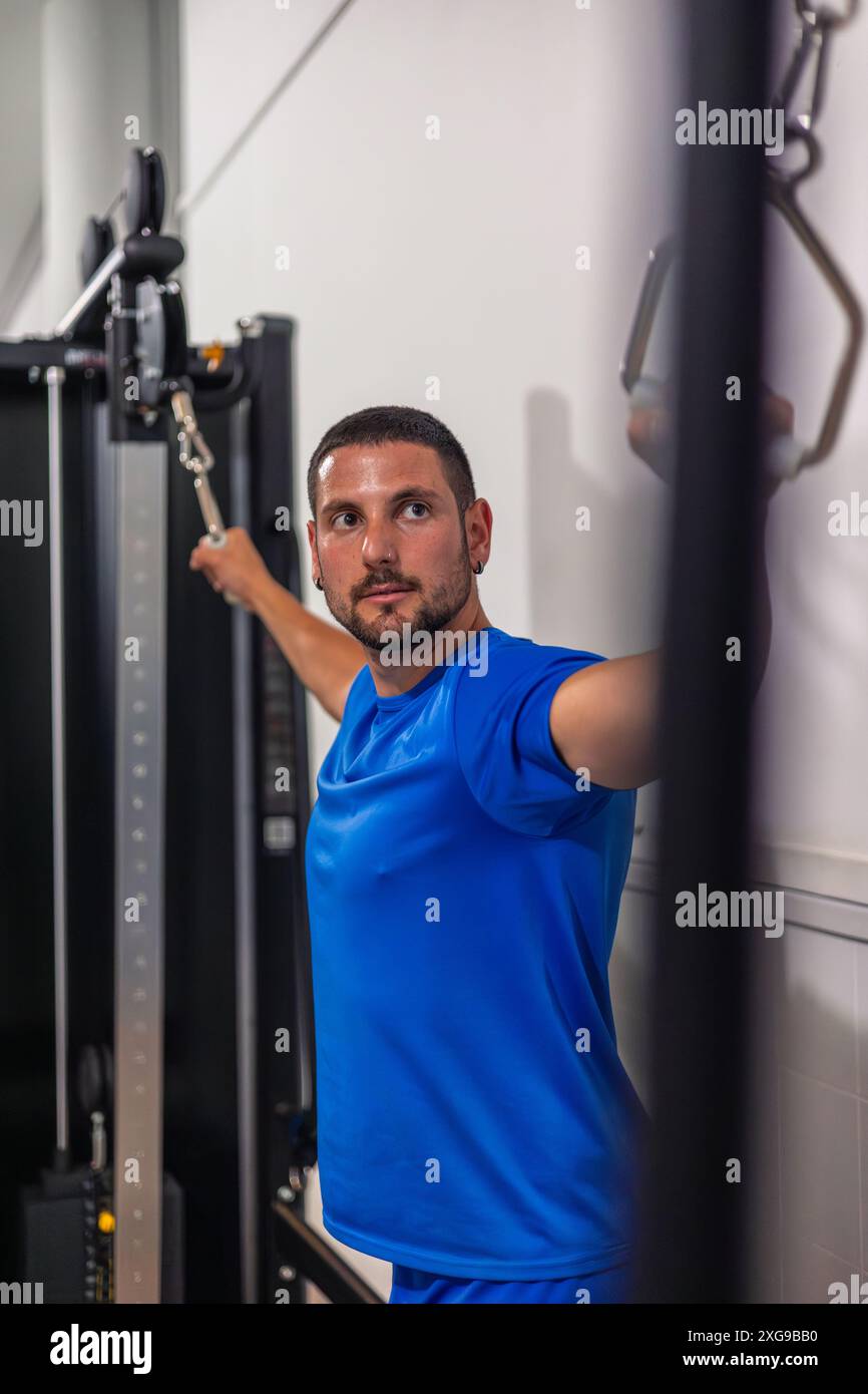 vertical portsman is training his back deltoid muscles using cable ...