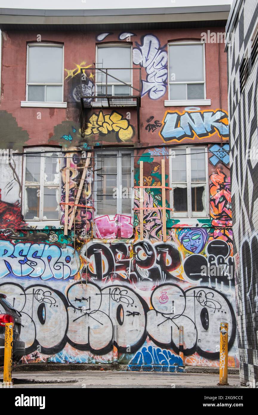 Graffiti tagged on a building in an alley near Saint-Laurent Boulevard ...