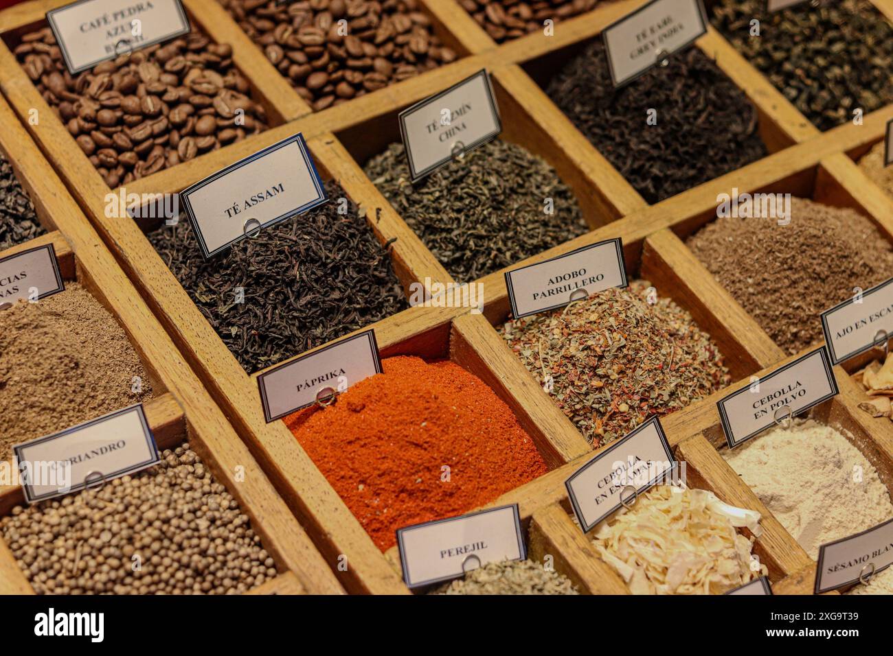 exotic condiments and spices on a wooden display with square divisions ...