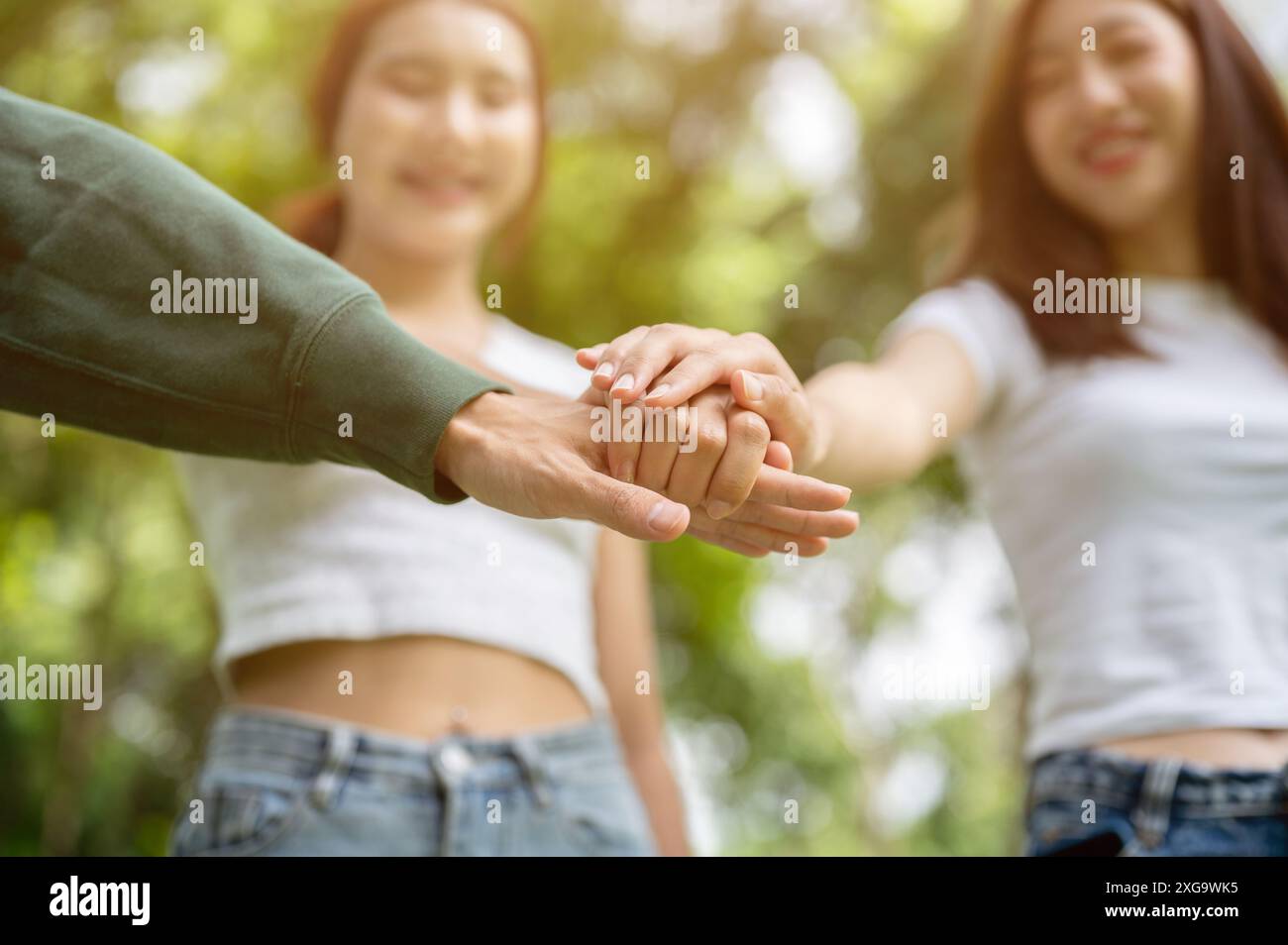 A close-up image of a group of friends putting their hands together ...