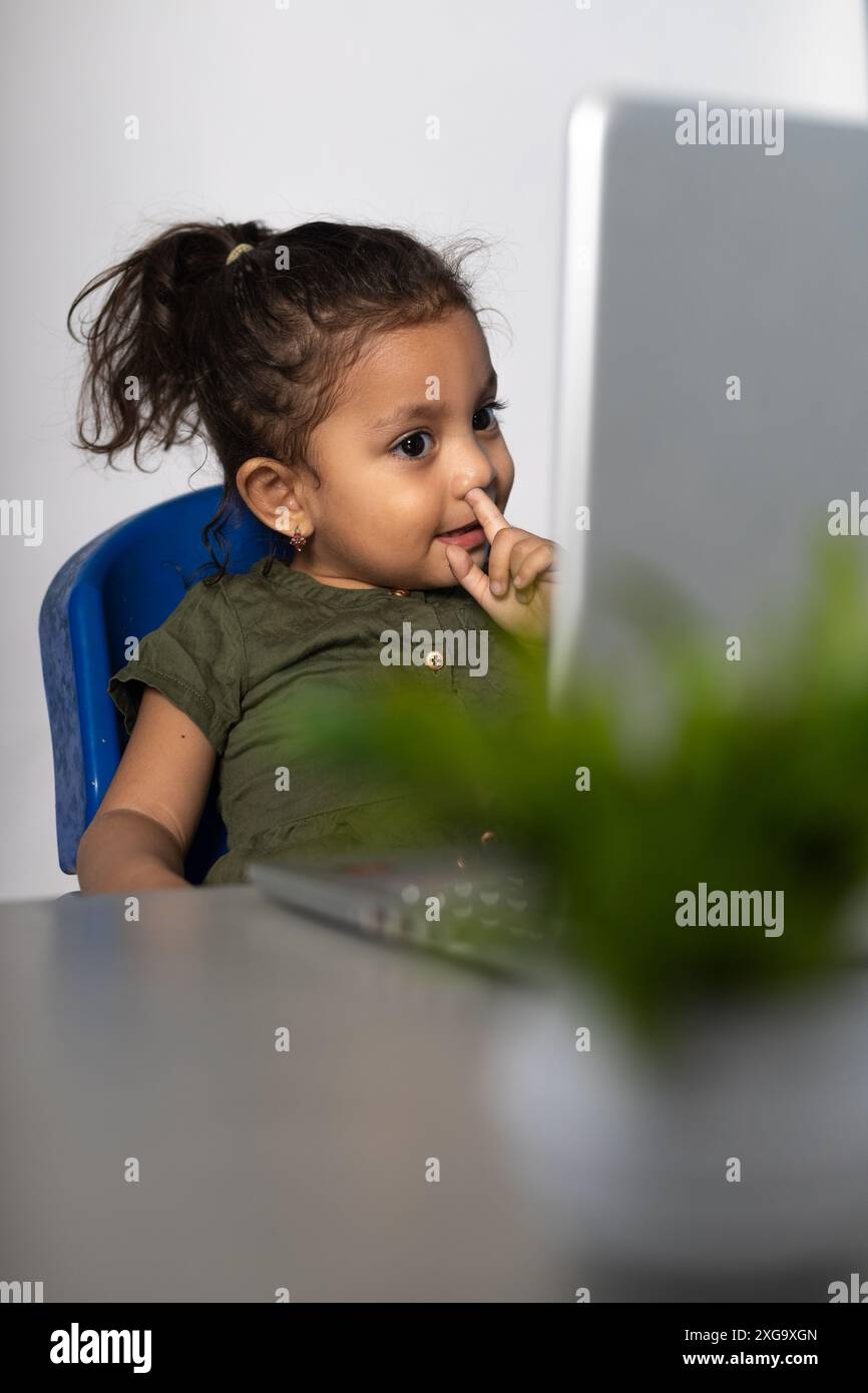 Beautiful 2 years Latina girl Mexican sitting focused Picking her nose ...