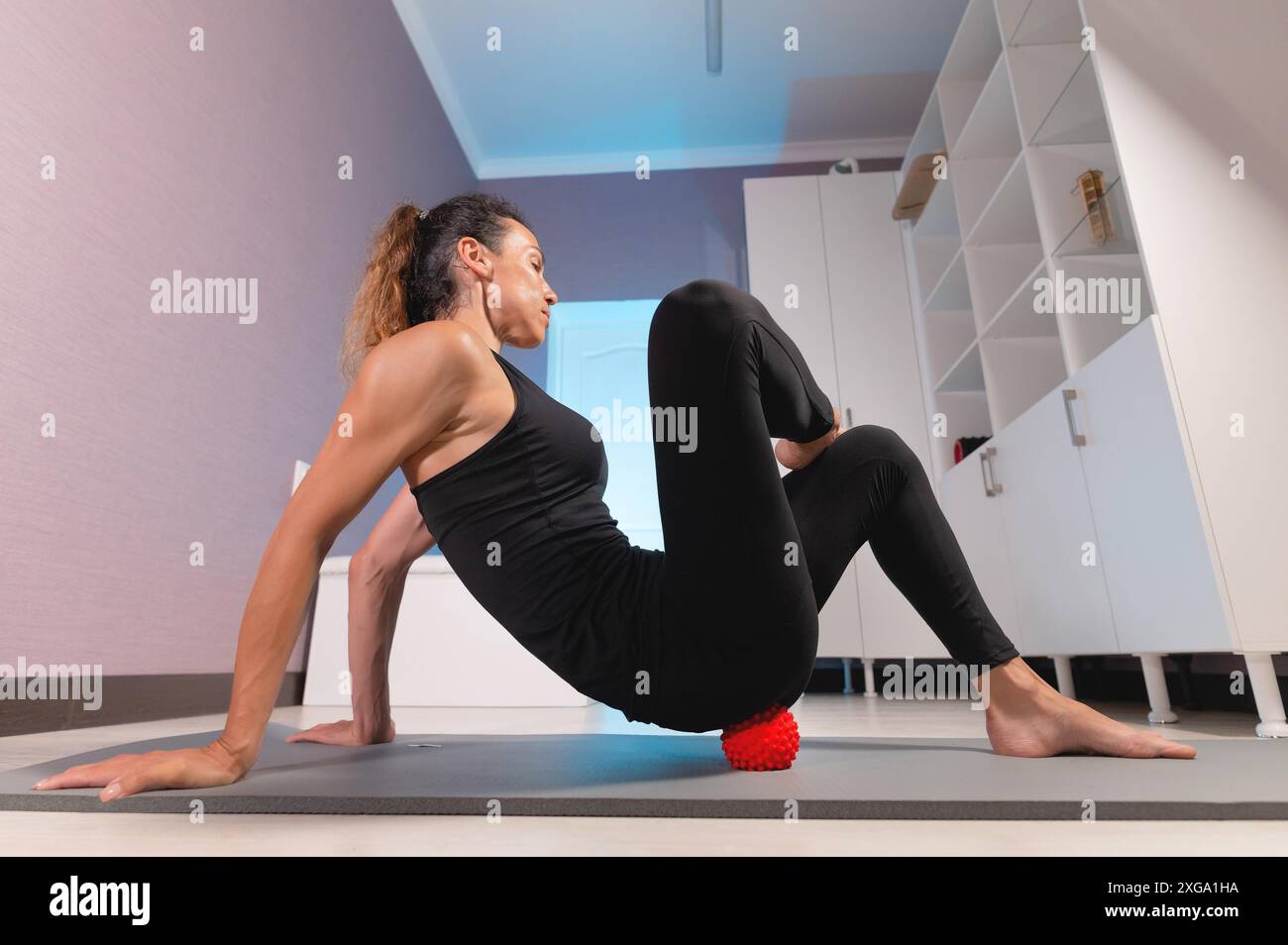Close-up of female caucasian woman doing myofascial self-massage of her ...