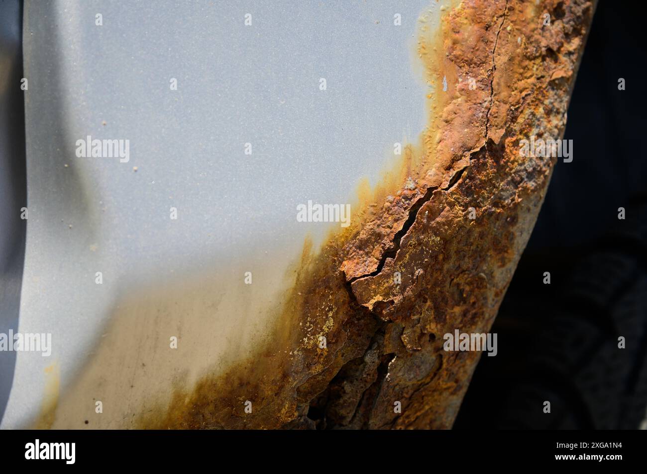 Fragment of a car body with rust. fragment of a rusty wing of a car ...