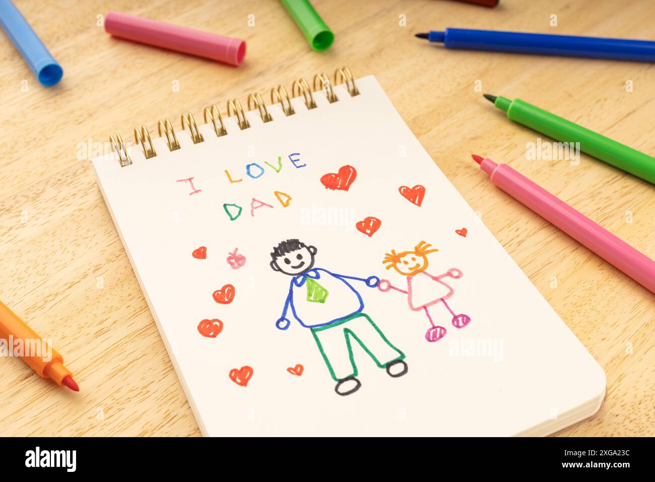 Fathers day concept. Notebook with drawing of a father with a girl and ...
