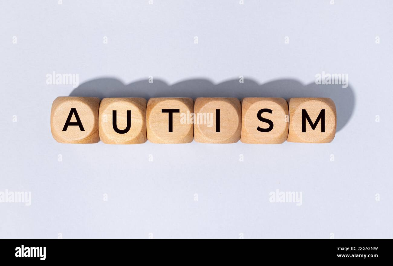 Autism word on wooden block isolated on gray background Stock Photo - Alamy