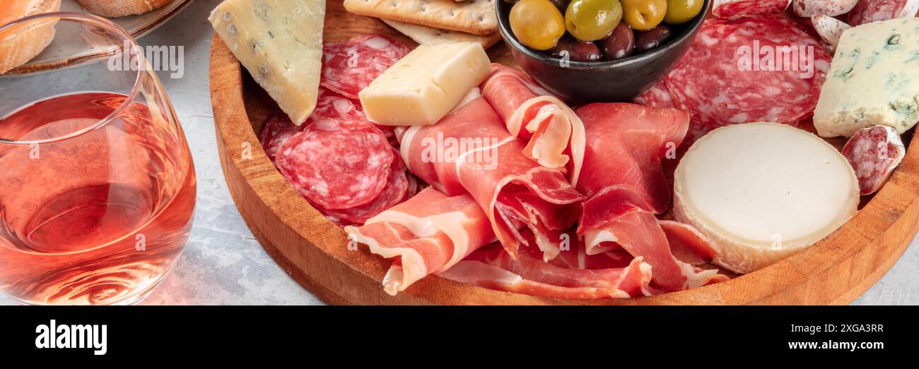 Rose wine with charcuterie and cheese board panorama. Italian antipasti ...
