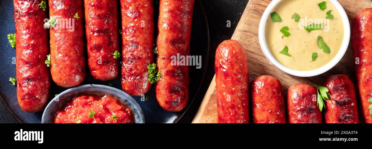 Grilled sausages with ketchup and mustard sauce panorama on a dark ...