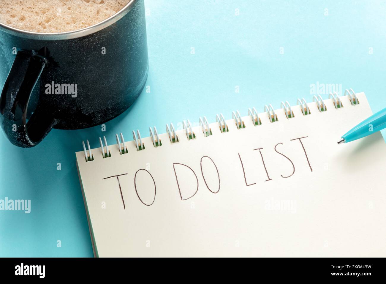 To do list, handwritten in a notepad, with a cup of coffee and a blue ...