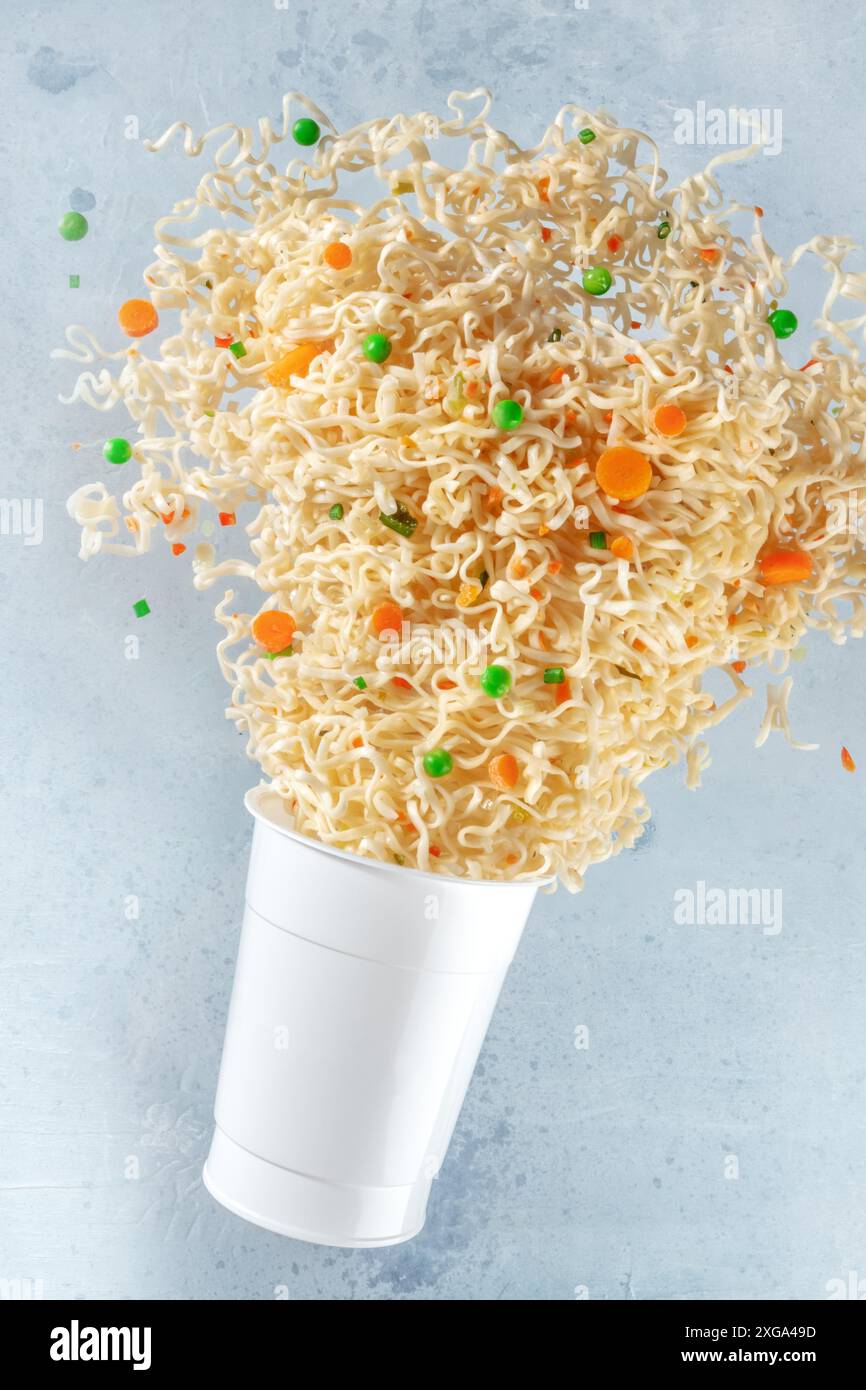 Ramen cup with noodles floating out of it, fast food levitation ...