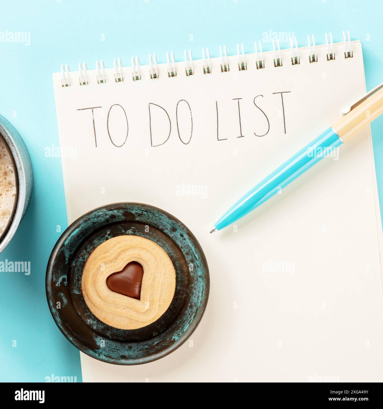 To do list square shot. A notepad with a blue pen and a cookie, shot ...