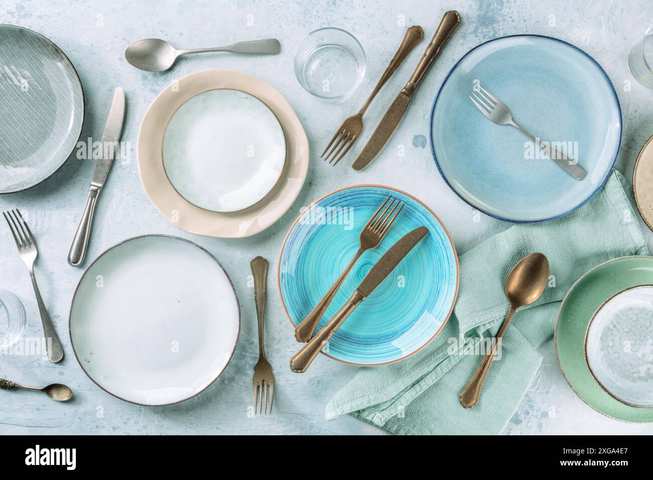 Modern tableware set with cutlery and a vibrant blue plate, overhead flat lay shot Stock Photo ...