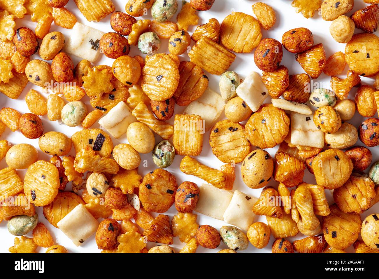 Japanese rice crackers, scattered on a white background, overhead flat ...