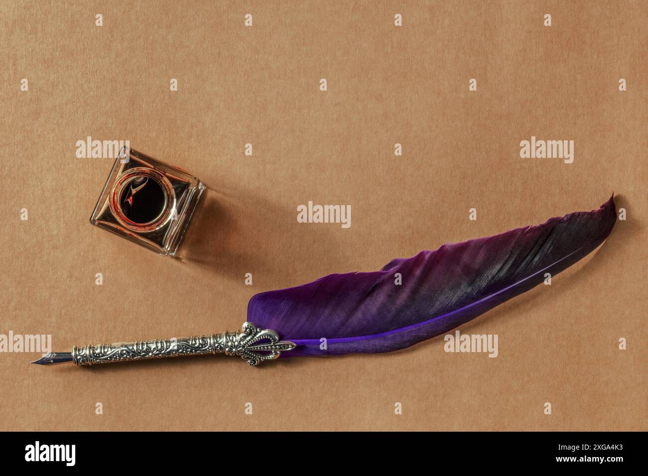 A quill pen with a vintage ink well, overhead flat lay shot on brown ...