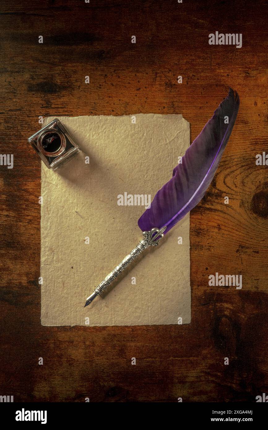 A quill pen with a vintage ink well and a piece of old paper, overhead ...