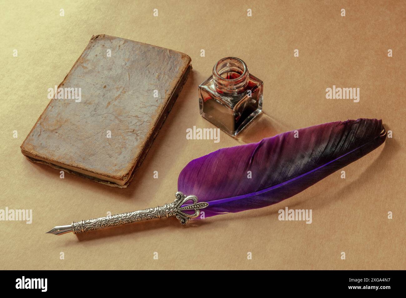 A quill pen, a vintage ink well, and an old notebook, retro objects on ...