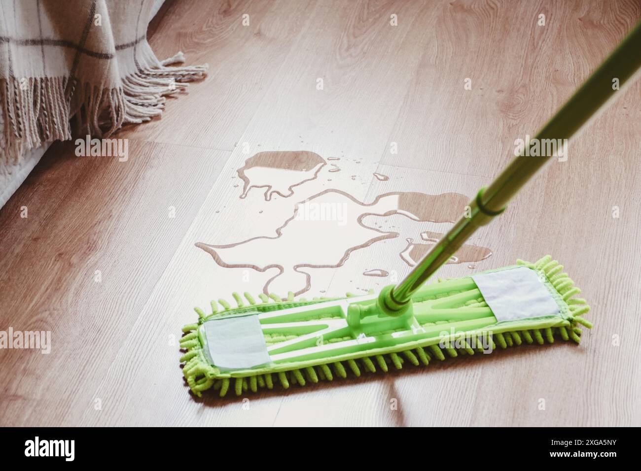 Water on the laminated wooden floor in bedroom, mop wiping wet floor ...