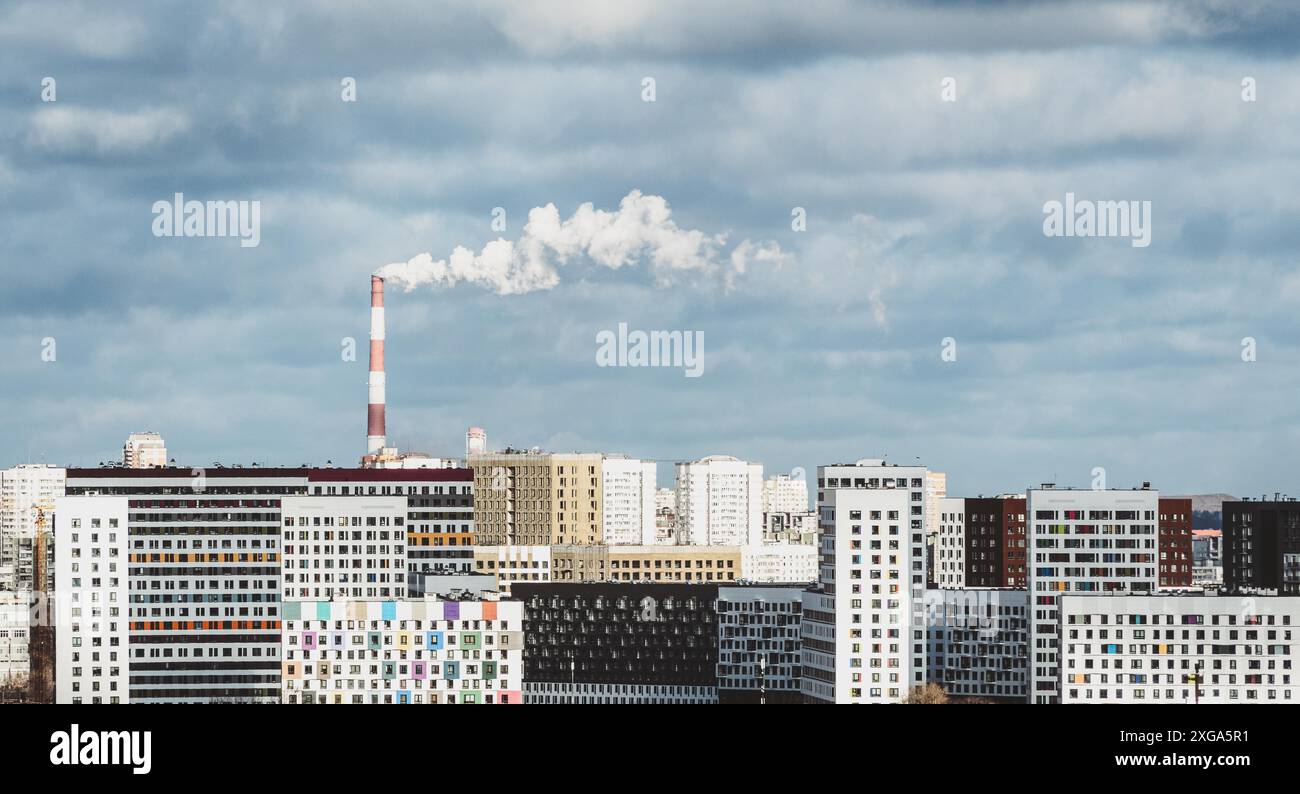 Smoking factory chimney, modern residential buildings of bedroom suburb ...
