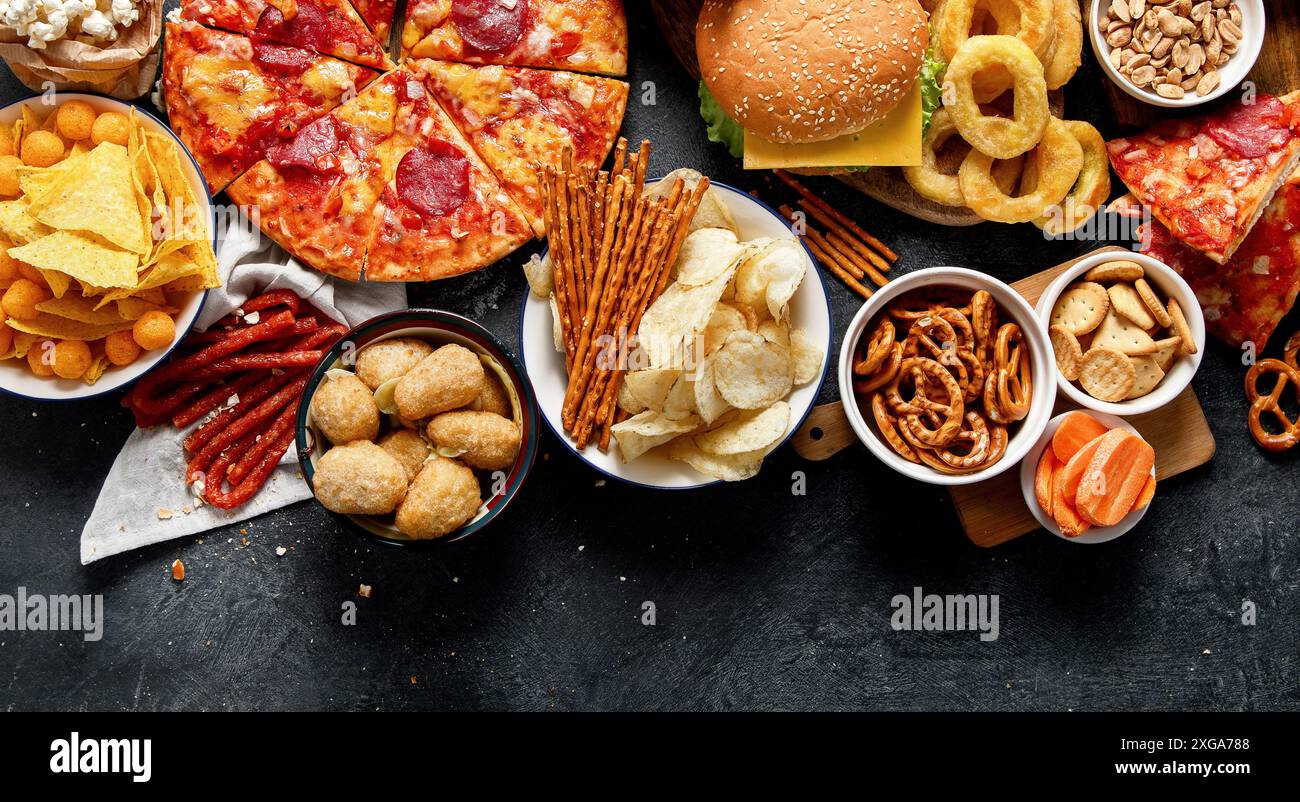 Large table of assorted take out food such as pizza, french fries ...