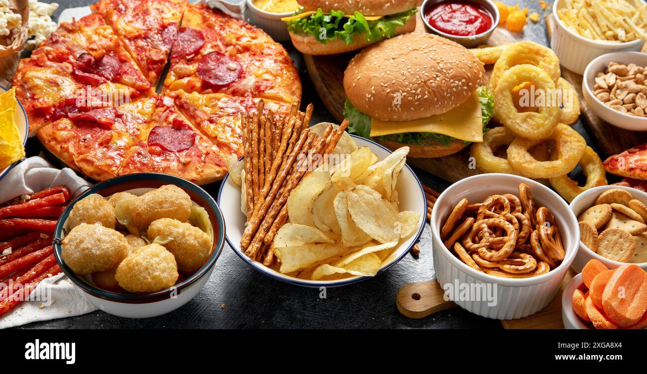 Large table of assorted take out food such as pizza, french fries ...