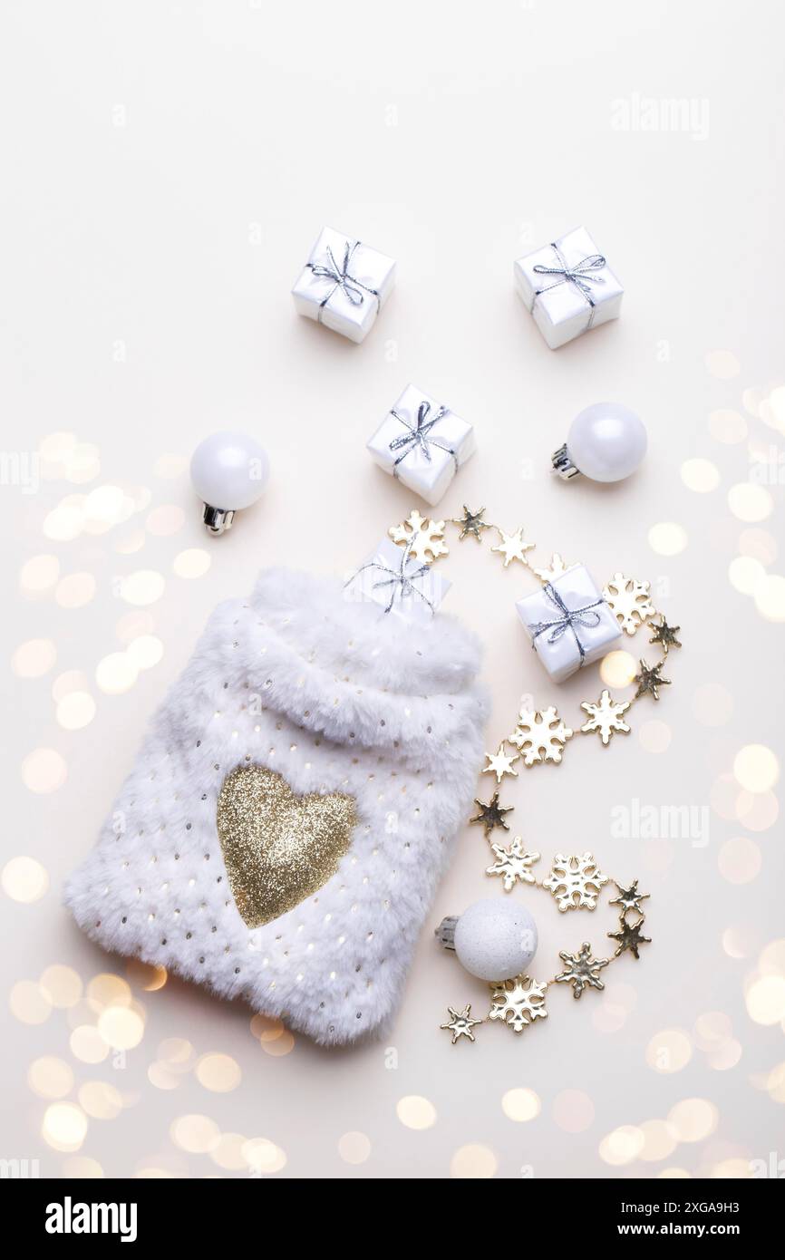 White fluffy sack with small gift boxes on beige background, flat lay ...