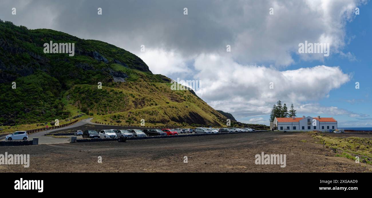 Car park with many cars next to a white house and thermal bath in a ...