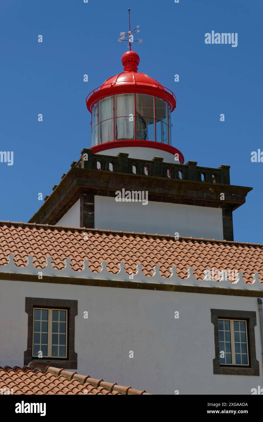Detailed view of a lighthouse with red top and window facades under a ...